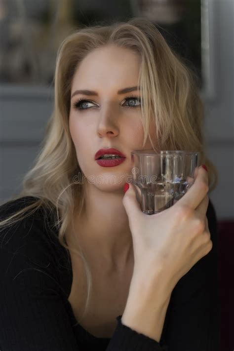 A Beautiful Long Haired Blond Girl Wearing A Mini Skirt Is Sitting And