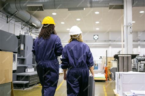 Operárias De Fábrica De Capacetes E Macacões Andando No Chão Da Fábrica