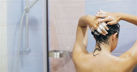 젊은 행복한 여자는 샴푸로 머리를 씻고 손으로 거품을 낸다 샤워를 하고 휴식 시간을 즐기는 아름다운 갈색 머리 소녀 몸 머리카락 및 피부 위생 라이프 스타일 개념