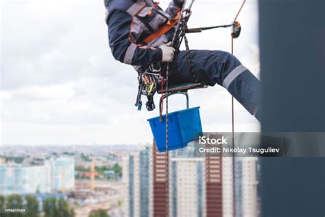 전문 등반가 로프 접근 작업자는 주거용 초고층 빌딩 고층 건물 외벽의 정면에 창문을 페인팅 수리 및 청소하고 높은 곳에서 작업하는 산업 산악인입니다 일함에 대한 스톡 사진