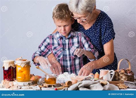 Grandmother With Grandson Cooking Kneading Dough Baking In The