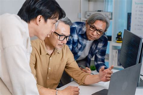 Team Of Developers Collaborating In Brainstorming And Coding Project At Office Workspace Stock