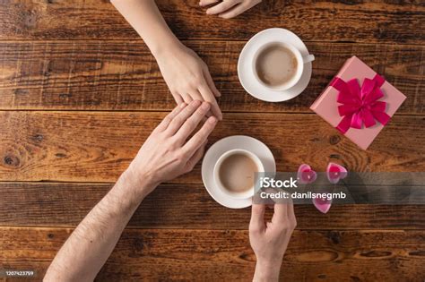 발렌타인 데이 축하 개념입니다 사랑하는 사람을위한 좋은 선물 나무 테이블 배경에 커피 잔과 남자와 여자의 손 공간을 복사합니다 플랫 레이 클로즈업 2명에 대한 스톡 사진 및