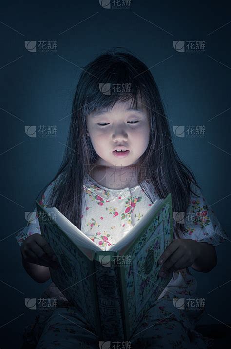 女孩在黑暗的背景下看书