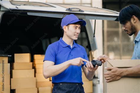 Asian Delivery Man Hand Using Smart Phone To Scan QR Code On Tag Concept Of Parcel Delivery