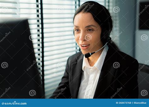 Competent Female Operator Working On Computer And While Talking With Clients Stock Photo