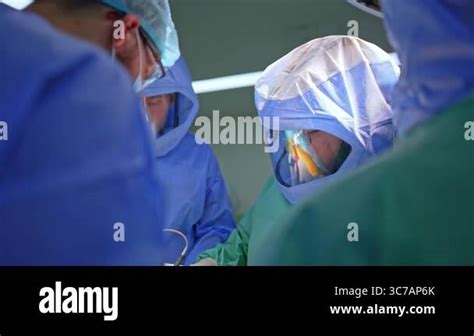 Uniformed Male Medics Cooperating At Surgery Surgeons Wear Protective