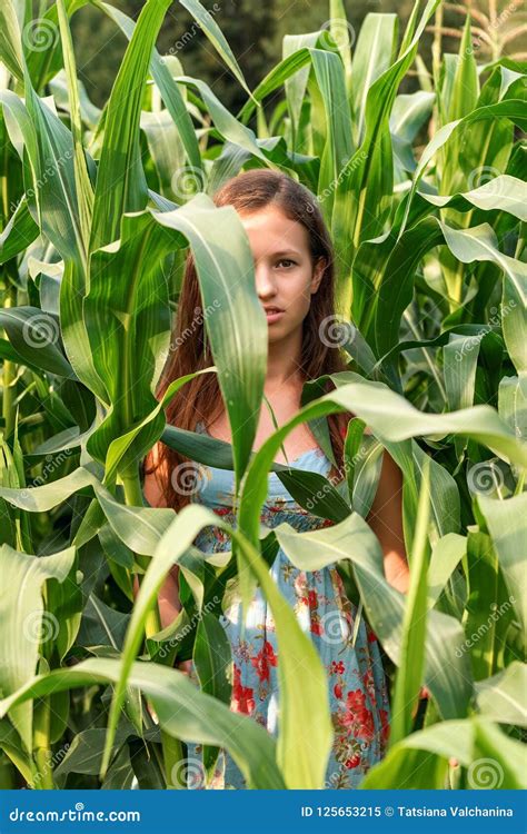 Close Portrait Of A Girl On A Cornfield Field And A Half Face Close Up
