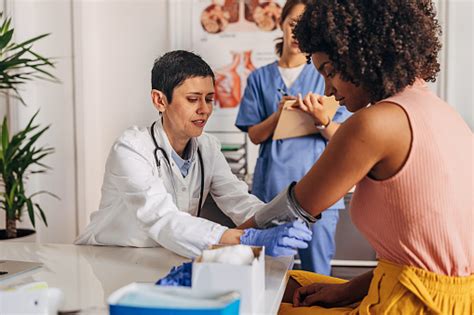 간호사가 의료 차트에서 메모를하는 동안 여성 의사는 환자의 혈압을 검사하고 있습니다 3 명에 대한 스톡 사진 및 기타 이미지