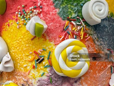 여러 가지 빛깔의 설탕 뿌리와 과자와 사탕 모양의 퐁당 아이싱으로 장식된 무지개 색 아이스 생일 케이크 표면의 전체 프레임 이미지 전경에 초점 0명에 대한 스톡 사진 및