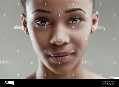 Intimate Portrait Showcasing A Womans Faint Smile And Piercing Gaze