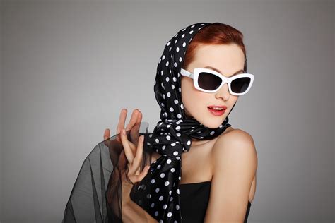 Фото Красивая девушка в очках и черном платке в белый горошек