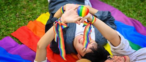 Young People Lying On Green Grass With Lgbtq Pride Flag Supporting