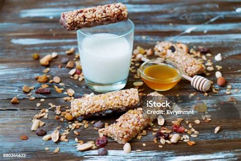 높은 단백질 그 라 놀라 에너지 바 고 어두운 갈색 나무 테이블 건조 과일 혼합된 견과류와 꿀 건강 한 슈퍼 푸드에 우유의 유리 보기 상위 클로즈업 0명에 대한 스톡 사진