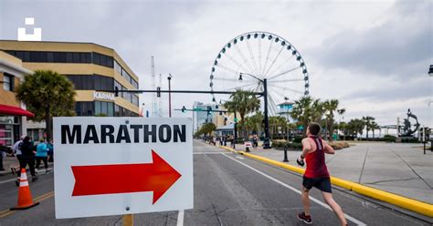 노란색 티셔츠와 파란색 데님 반바지를 입은 남자가 낮에 도로를 달리고 있습니다 사진 Unsplash의 무료 달리기 이미지