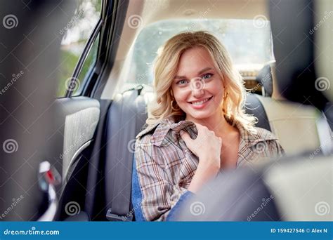 Photo Of Blonde Woman Looking At Camera Sitting In Back Seat Of Car