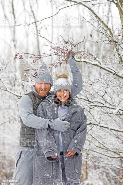 아름 다운 갈색 머리 여자와 사랑 하는 강아지와 놀고 눈 야외에서 성인 커플으로 남성 빨간 머리 12월에 대한 스톡 사진 및