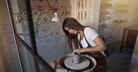 도자기 작업장에 앉아 도자기 바퀴를 돌리는 점토 조각을 만드는 도구를 사용하는 여성 장인 사진 Unsplash의 바퀴 이미지