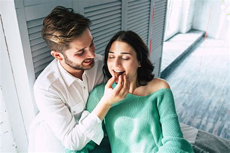 내 사랑에 대 한 초콜릿입니다 남자 손에 사탕을 보유 하 고 그들은 침대에 누워 있는 동안 그의 아름 다운 젊은 Wonan에 그것을 준다합니다 2명에 대한 스톡 사진 및