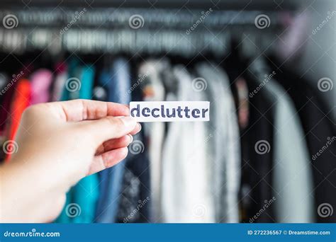 Shopping And Consumerism Declutter Sign Held In Front Of Wardrobe Full