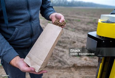 토양 샘플링 연구 실험실의 엔지니어 직원이 종이 패키지에 토양 샘플을 포장합니다 토양 프로브 샘플러로 샘플을 채취하는 토양