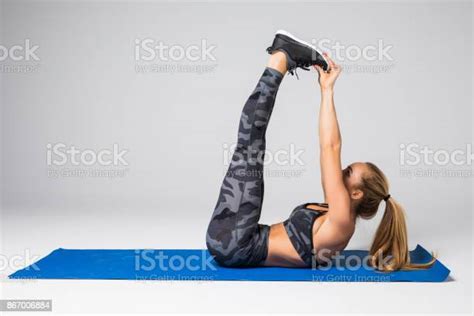 밖으로 일 하는 아름 다운 젊은 모델 회색에 매트에 요가 연습을 스트레칭 하 고 스포츠 액티브 라이프 스타일 개념입니다 전체 길이 측면 보기 건강한 생활방식에 대한 스톡