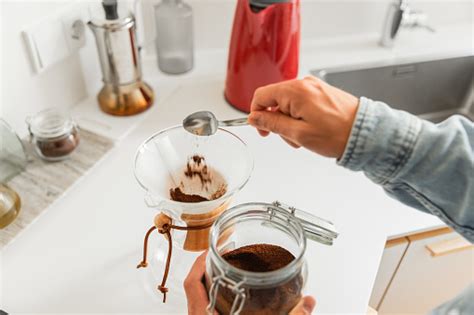 부엌에서 커피 메이커와 물방울 주전자를 사용하여 커피를 준비하는 젊은 남자 출근 전 아침 루틴 30 34세에 대한 스톡 사진 및