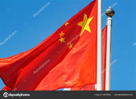Flag Of China Close Up Waving On The Wind On A Blue Sky Background
