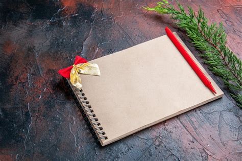 Free Photo Front View Red Pen A Notepad With Little Bow A Pine Tree Branch On Dark Red Background