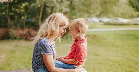 젊은 백인 어머니와 소년 유아 아들이 얼굴을 맞대고 함께 앉아 있습니다 가족 엄마와 아이는 여름날 야외에서 의사 소통을합니다 행복 한 정통 가족 어린 시절 생활 방식