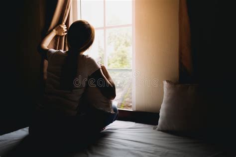 Lonely Single Asian Woman Sit Alone In Dark Bedroom With Light From