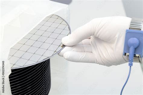 Gloved Hand Holding A Silicon Wafer In Plastic Holder Box Used In Electronics For The