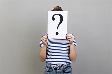 물음표가 있는 종이 뒤에 얼굴을 숨기고 서 있는 여자는 해결에 문제가 있다 마스크에 대한 스톡 사진 및 기타 이미지 마스크