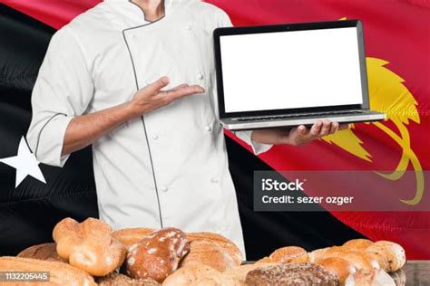파푸아 뉴기니 국기와 빵 배경에 노트북을 들고 베이커 요리사가 복사 공간에 대 한 균일 한 포인팅 빈 화면을 착용 고급 요리에 대한 스톡 사진 및 기타 이미지 Istock