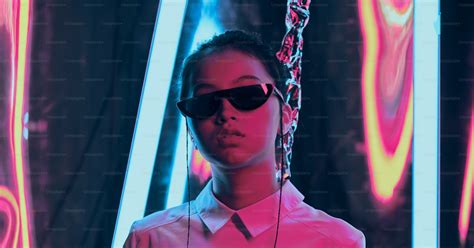 세련된 초승달 모양의 선글라스를 쓴 젊은 아시아 십대 소녀의 초상화 빨간색과 파란색 네온 불빛 사이버 미래 지향적인 초상화 개념 사진 Unsplash의 초상 이미지