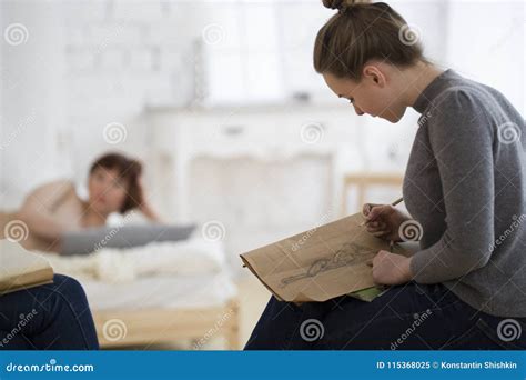 El Artista De Sexo Femenino Joven Dibuja El Modelo Desnudo En Clase De Dibujo Imagen De Archivo