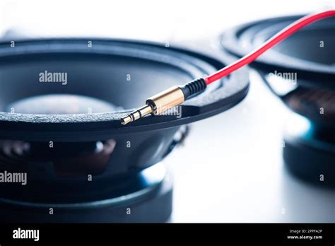 Close Up Red Aux Auxiliary Cable With Male Jack With Speaker In The Background Cable For