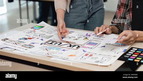 Ux Developer And Ui Designer Brainstorming About App Interface Wireframe Design On Table With