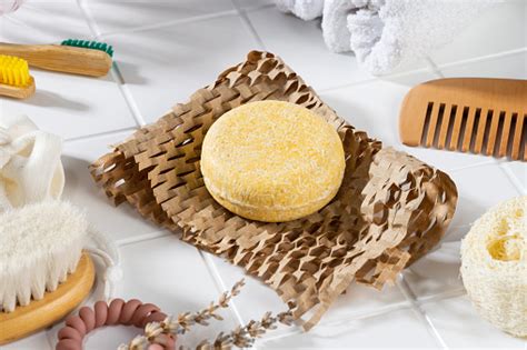 친환경 고체 샴푸 바와 천연 욕실 액세서리가 벌집 종이 흰색 욕실 배경에 누워 있습니다 플라스틱 무료 폐기물 제로 낮은 물 성분 지속 가능한 모발 관리 녹말 알갱이에 대한