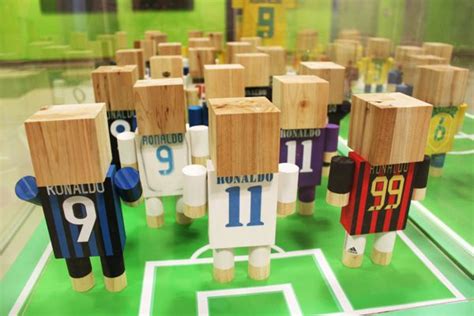 several wooden toy figures on a soccer field with the number nine in ...