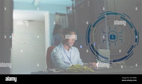Image Of Padlock In Circle Over African American Male Engineer Using Laptop At Data Centre Stock