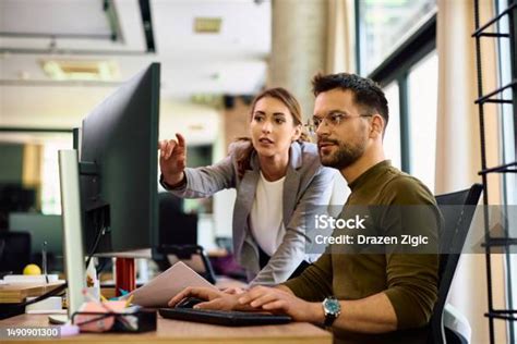 젊은 동료들이 사무실에서 컴퓨터 작업을 하는 동안 협력하고 있다 사무실에 대한 스톡 사진 및 기타 이미지 사무실 직업 일함 Istock