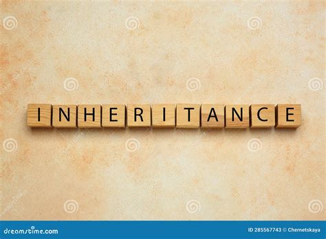 word inheritance made with wooden cubes on beige background flat lay