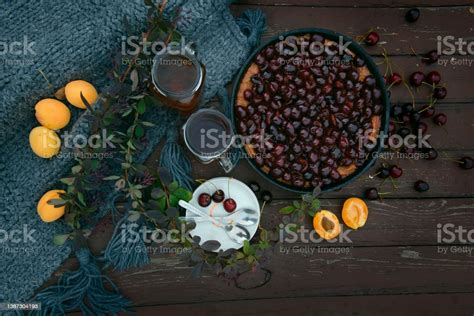 소박한 나무 배경에 신선한 체리와 체리 파이 나무 테이블에 파이 차 한 잔 과일로 정중합니다 아늑한 분위기와 2인용 로맨틱한