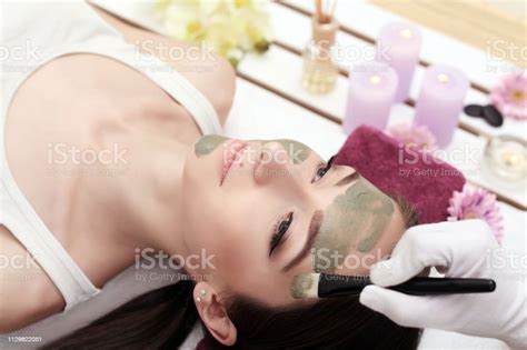 닥터 뷰티 살롱에서 젊은 여자의 얼굴에 막대기로 마스크를 적용 하는 클렌징과 피부 보습의 절차에 대 한 미용사입니다 미용 하 고 전문 피부 관리입니다 가꿔주기에 대한 스톡