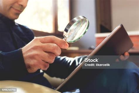 남자 그의 디지털 태블릿을 사용 하 여 인터넷에서 검색 하는 돋보기를 들고 돋보기 광학 기기에 대한 스톡 사진 및 기타 이미지 돋보기 광학 기기 사무실 읽기 Istock