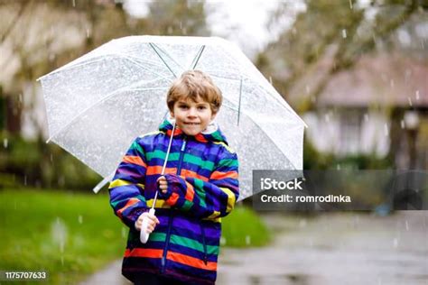 추운 날에 우산으로 진눈깨비 비 눈 동안 학교에 가는 길에 아름다운 어린 소년 화려한 패션 캐주얼 옷을 입고 행복하고 즐거운