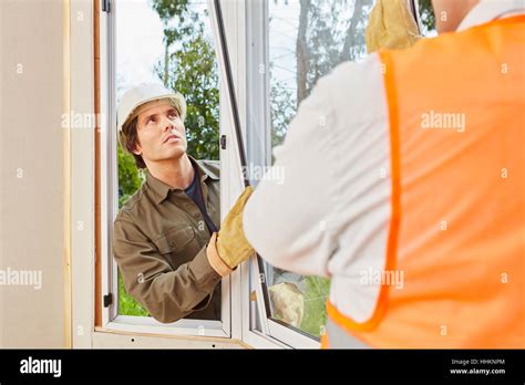 Two Men Installing Window Mount At Construction Site Stock Photo Alamy