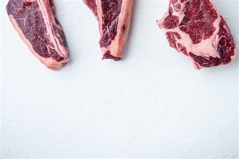 원시 블랙 앵거스 프라임 드라이 숙성 육류 스테이크 토마호크 T 뼈 또는 포터 하우스와 클럽 스테이크 흰색 돌 배경에 상단 보기 플랫 레이 텍스트복사 공간 갈비 스테이크에