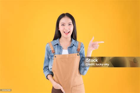 예쁜 아시아 여성 스마일 커피 프리랜서 자신의 커피 바 숍은 커피 종이 컵을 들고 자신의 상점 노란색 배경에서 신용 카드를 스